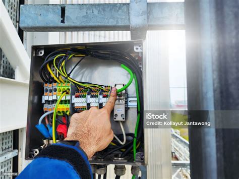 전기 기술자는 유지 보수 작업을 수행하고 전원 상자를 확인하며 통신 케이블로 배선 된 케이블이 있으며 손으로 터치하여 확인합니다 동축 케이블에 대한 스톡 사진 및 기타