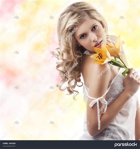 پرتره زیبایی کلاسیک زن جوان و زیبا با لیلی نارنجی و موهای فرفری با