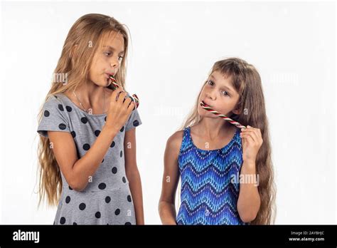 Deux Jeunes Filles Sucer Des Bonbons Au Caramel Photo Stock Alamy