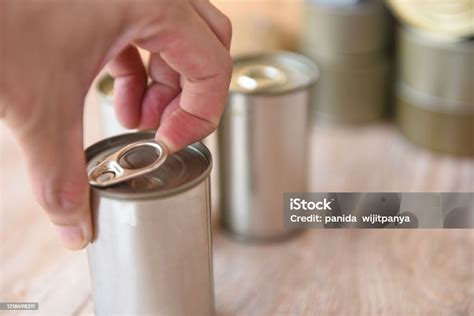 나무 배경에 금속 캔에 손으로 통조림 식품 부엌 가정에서 부패하기 쉬운 식품 저장 상품을 닫아 강철에 대한 스톡 사진 및 기타 이미지 Istock