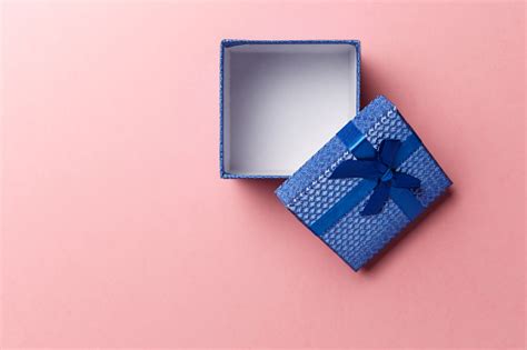 분홍색 배경에 파란색 리본파란색 빈 선물 상자입니다 맨 위 보기 플랫 레이 공간을 복사합니다 다채로운 배경 최소한의 크리스마스 새해 창조적 인 개념 트렌디한 파스텔 칼라