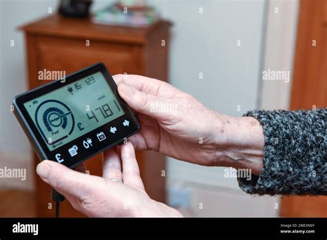 A Senior Woman Looks At The Smart Meter To Budget For Energy Bills For The Household Stock Photo