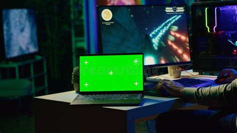 Green Screen Laptop Next To Man Having Fun By Using Gaming Keyboard To