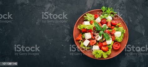 접시에 샐러드입니다 죽은 태아의 치즈 체리 토마토 파프리카 상 추 건강 한 음식입니다 돌 테이블에 최고의 볼 수 있습니다 텍스트에 대 한 여유 공간입니다 0명에 대한 스톡