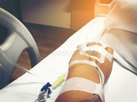 Закройте вверх по руке молодого пациента с внутривенным катетером для Inj Стоковое Изображение