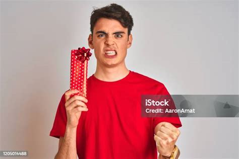 고립 된 배경을 통해 생일 선물을 들고 십대 소년은 화가 좌절 분노와 함께 외치고 미친 소리와 함께 고함 제기 손으로 분노 개념 격노한에 대한 스톡 사진 및 기타 이미지