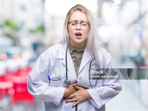 젊은 금발 의사 여자에 절연 배경 속에 손으로 하기 때문에 소화 불량 고통 스러운 질병 기분이 나쁘다 통증 개념입니다 건강관리와 의술에 대한 스톡 사진 및 기타 이미지