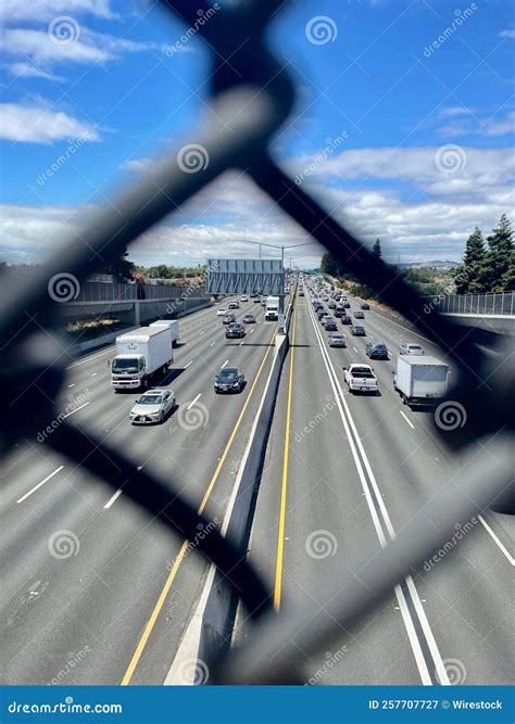 Vertical View Down The Freeway Hwy 880 Through A Chain Link Fence
