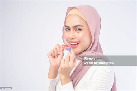 흰색 배경 스튜디오 치과 의료 및 치열 교정 개념을 통해 치아에 대한 다채로운 보유자를 들고 젊은 무슬림 여성 개선에 대한 스톡 사진 및 기타 이미지 Istock