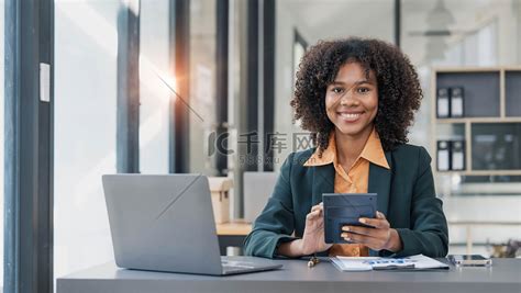 女商人使用计算器在办公室和商业工作背景、税务、会计、统计和分析研究概念的木桌上做数学金融。高清摄影大图 千库网