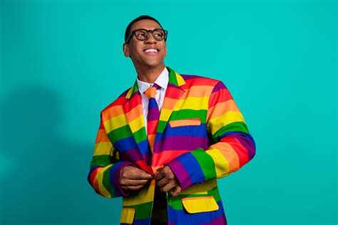 생생한 줄무늬 무지개 양복을 입은 카리스마 넘치는 젊은이가 생생한 청록색 배경을 배경으로 서 있습니다 30 34세에 대한 스톡 사진 및 기타 이미지 Istock