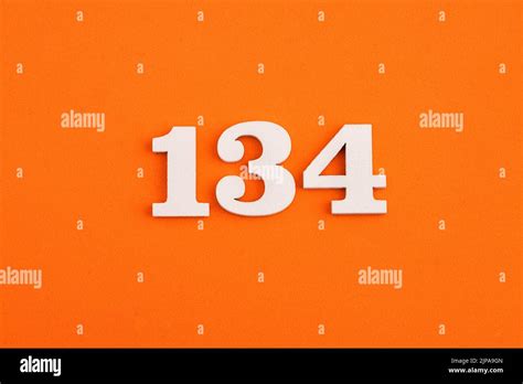 White wooden number 134 on eva rubber orange background Stock Photo - Alamy