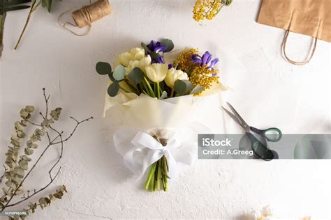 꽃의 봄 꽃다발입니다 홍채 튤립 미모사 및 유칼립투스 노란색과 파란색 꽃입니다 새싹 클로즈업 꽃 배경입니다 보라색 홍채 흰색 더블 튤립 3 월 분위기 부케에 대한 스톡 사진