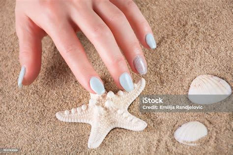 여성 손 손가락 손톱에 파란색 매니큐어와 모래 해변에 바다 불가사리 개념에 대한 스톡 사진 및 기타 이미지 개념 껍데기 노랑 Istock
