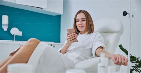 허리 위쪽 측면보기 흰색 목욕 가운을 입은 젊은 예쁜 백인 여성의 초상화는 웰빙 클리닉에서 정맥 비타민 점적 치료를 받고 있습니다 사진 Unsplash의 팔 이미지