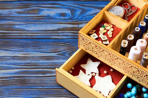 바느질과 바느질을 위한 패턴이 있는 열린 노란색 상자 조각과 파란색 나무 배경에 실과 장식 실 공이 있습니다 0명에 대한 스톡 사진 및 기타 이미지 Istock