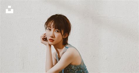 파란색과 흰색 스파게티 스트랩 드레스를 입은 여자 갈색 나무 벤치에 앉아 사진 Unsplash의 무료 유행 이미지