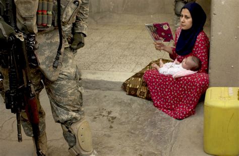 An Iraqi Woman Looks On As Us Army Soldiers From 1st Battalion 23rd Infantry Regiment 3rd