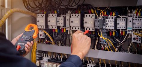 Electrical Engineer Using Measuring Equipment To Checking Electric Current Voltage At Circuit