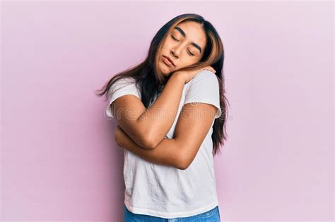 Young Latin Woman Wearing Casual White Tshirt Hugging Oneself Happy And