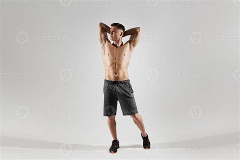 Handsome Muscular Man Showing His Perfect Body While Standing Against