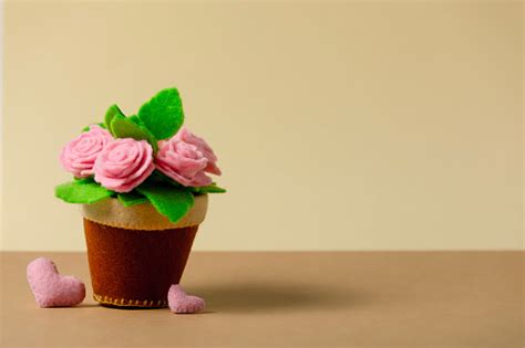 수제 냄비는 분홍색 하트가있는 노란색 빈 잎이있는 베이지 색 배경에 장미를 느꼈습니다 공간을 복사합니다 어린이 기프트 컨셉 휴일 카드 축하 초대장 0명에 대한 스톡 사진 및