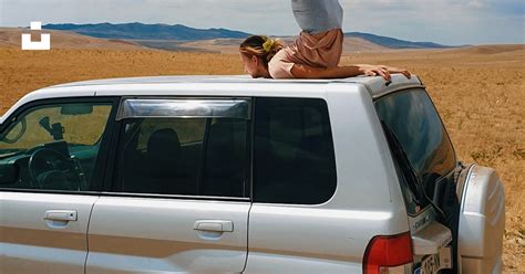 흰색 긴팔 셔츠와 갈색 바지를 입은 사람이 낮에 흰색 차에 앉아 있습니다 사진 Unsplash의 무료 바쉴로바니 이미지