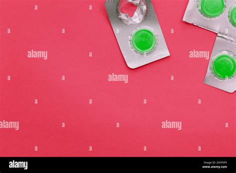 Green Pills On A Red Background In A Silver Package Medicines For