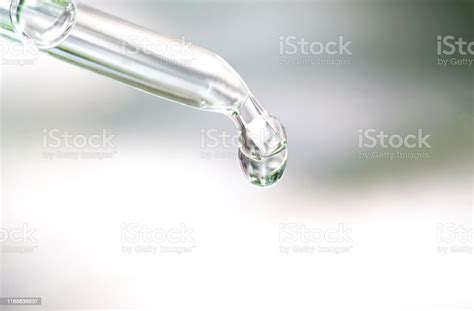 아름 다운 여자의 손 떨어지는 세럼 콜라겐 보습제 얼굴의 명확한 노란색 병 부드러운 빛 배경 프로텍터 스킨 트리트먼트 페이셜 에센스 오일 비타민 C 뷰티 앤 스파 콘