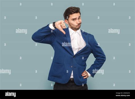 Portrait Of Dissatisfied Attractive Man With Mustache With Frowning Face Showing Thumb Up