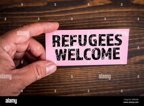 Refugees Welcome Text On Pink Paper Wood Texture Background Stock