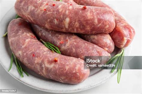 흰색 배경에 접시에 향신료와 로즈마리를 곁들인 생 소시지 또는 소세지 클로즈업 고기에 대한 스톡 사진 및 기타 이미지 고기 날것 독일 음식 Istock