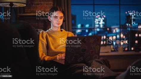 저녁에는 세련된 로프트 아파트의 노트북 컴퓨터에서 집에서 일하는 잘 생긴 남자 창조적 인 사람 소셜 미디어를 확인 인터넷 검색