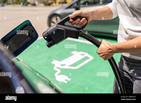 Hand Inserting A Dc Ccs2 Ev Charging Plug Into Electric Car Socket At Charging Station