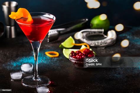 보드카 리큐어 크랜베리 주스 라임 얼음 오렌지 향 다크 바 카운터 배경 밤 분위기 텍스트 공간과 클래식 알코올 칵테일 코스모