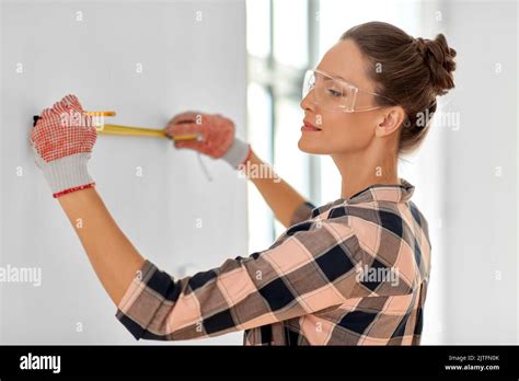 Woman With Ruler And Pencil Measuring Wall At Home Stock Photo Alamy