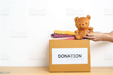어린이 기부 자선 자원 봉사 기부 및 배달 개념 곰 인형과 옷을 집에 있는 기부 상자에 넣고 가난하고 난민 노숙자를 지원하고