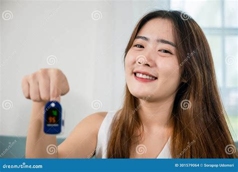 Woman Using Medical Oximeter Equipment To Measure Pulse Oxygen