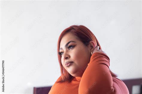 Portrait Of Hispanic Overweight Woman In Profile Touching Her Hair