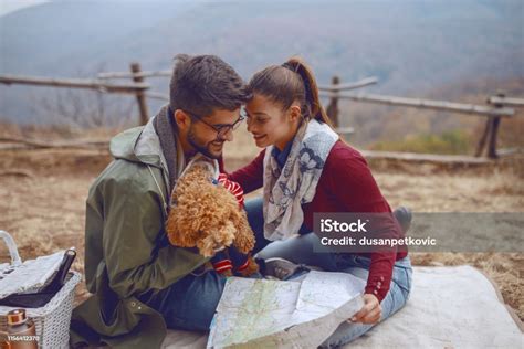 귀여운 다문화 부부는 자신의 개와 함께 자연담요에 앉아 유혹과 도보 투어를 계획 가을 컨셉의 피크닉 2명에 대한 스톡 사진 및 기타 이미지 Istock