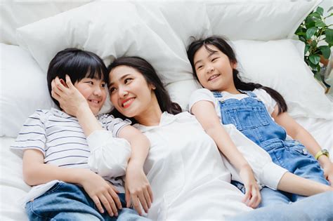 행복한 아시아 가족 미소 어머니 아들과 딸 에 침대에 침실에 엄마 아들과 딸은 집에서 함께 즐거운 시간을 보내고 있습니다 사랑과