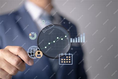 Premium Photo Smart Business Analyst Holding A Magnifying Glass Analyzing Graphs And Charts