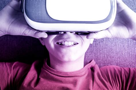 집에서 소파에 누워 가상 현실 고글 기술과 재미를 젊은 남자 Vr 헤드셋을 착용하고 놀란 소년 미소 기술 현대 라이프 스타일과