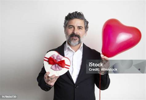 흰색 바탕에 풍선이 있는 빨간 하트 모양의 상자를 들고 양복을 입은 수염 난 남성 개념에 대한 스톡 사진 및 기타 이미지