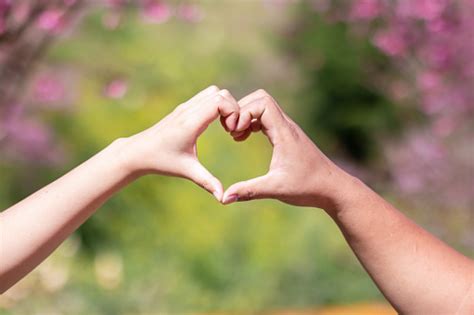 남성과 여성 커플은 마음이 사랑의 상징이기 때문에 우정의 사랑과 친절을 보여주기 위해 심장 상징을 형성하기 위해 손을 보여줍니다 하트 심볼로 사랑을 보여주는 남녀 커플 2