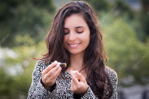 woman applying essential oil on a pill stock image c035 3877 science photo library