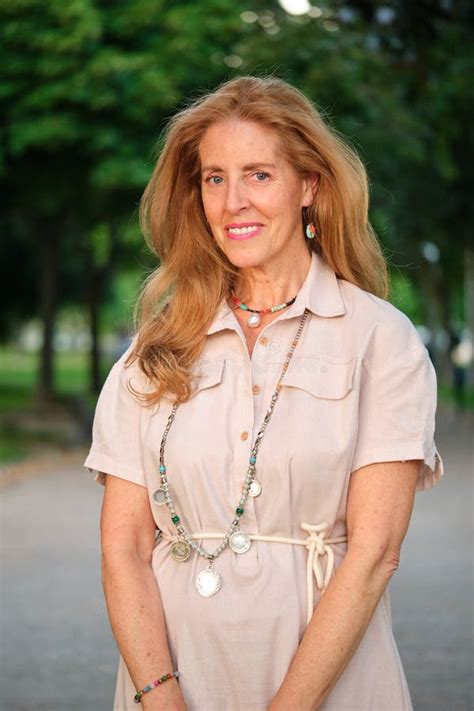 Outdoor Portrait Of Smiling Mature Blonde And Blue Eyed Woman Stock