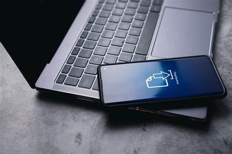 Premium Photo Smartphone Laying On Laptop While Downloading Files Or