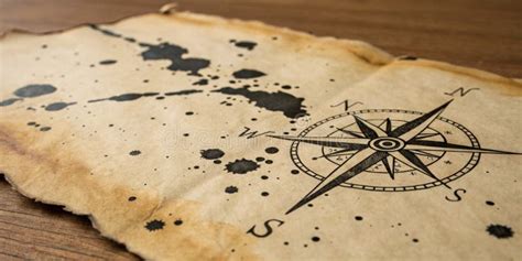 Antique Map With Compass Design And Ink Splatters On Wooden Surface