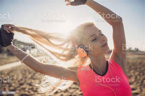 해변에서 음악을 듣고 젊은 아름 다운 여자의 초상화 이어폰 카메라 보고 웃는 금발 여자의 얼굴을 닫습니다 여자 비치에서 실행 하 고 음악을 듣고 Mp3 플레이어에 대한 스톡